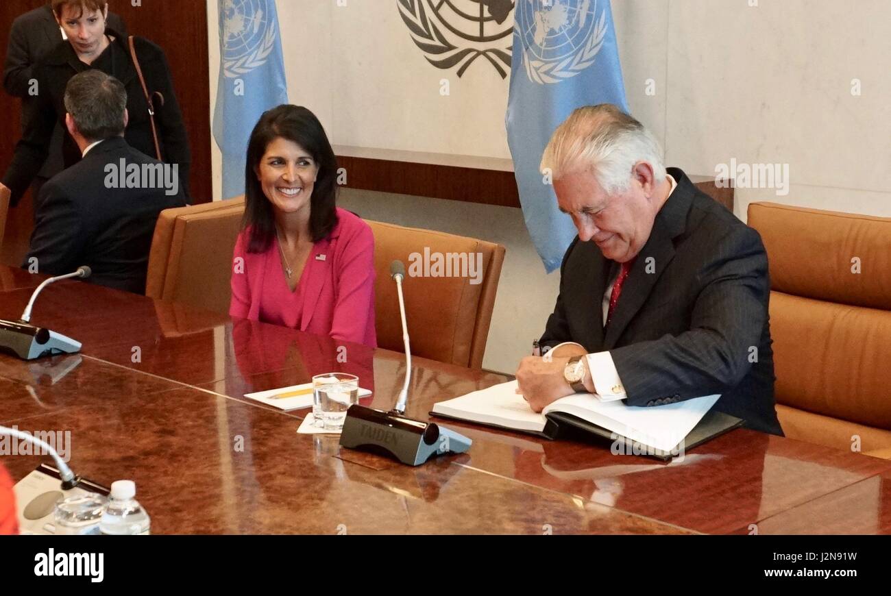 U.S. Secretary of State Rex Tillerson, right, signs the guest book as U ...