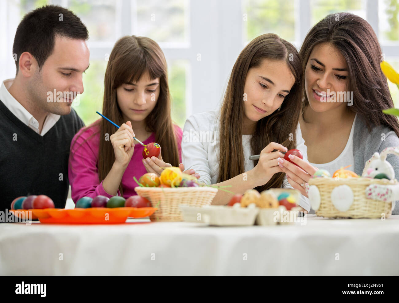 Happy family on Easter holiday decorating eggs Stock Photo - Alamy
