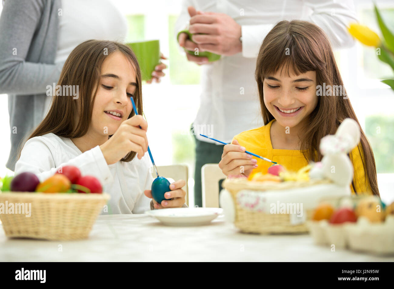 two cute twins girls painted Easter eggs Stock Photo - Alamy