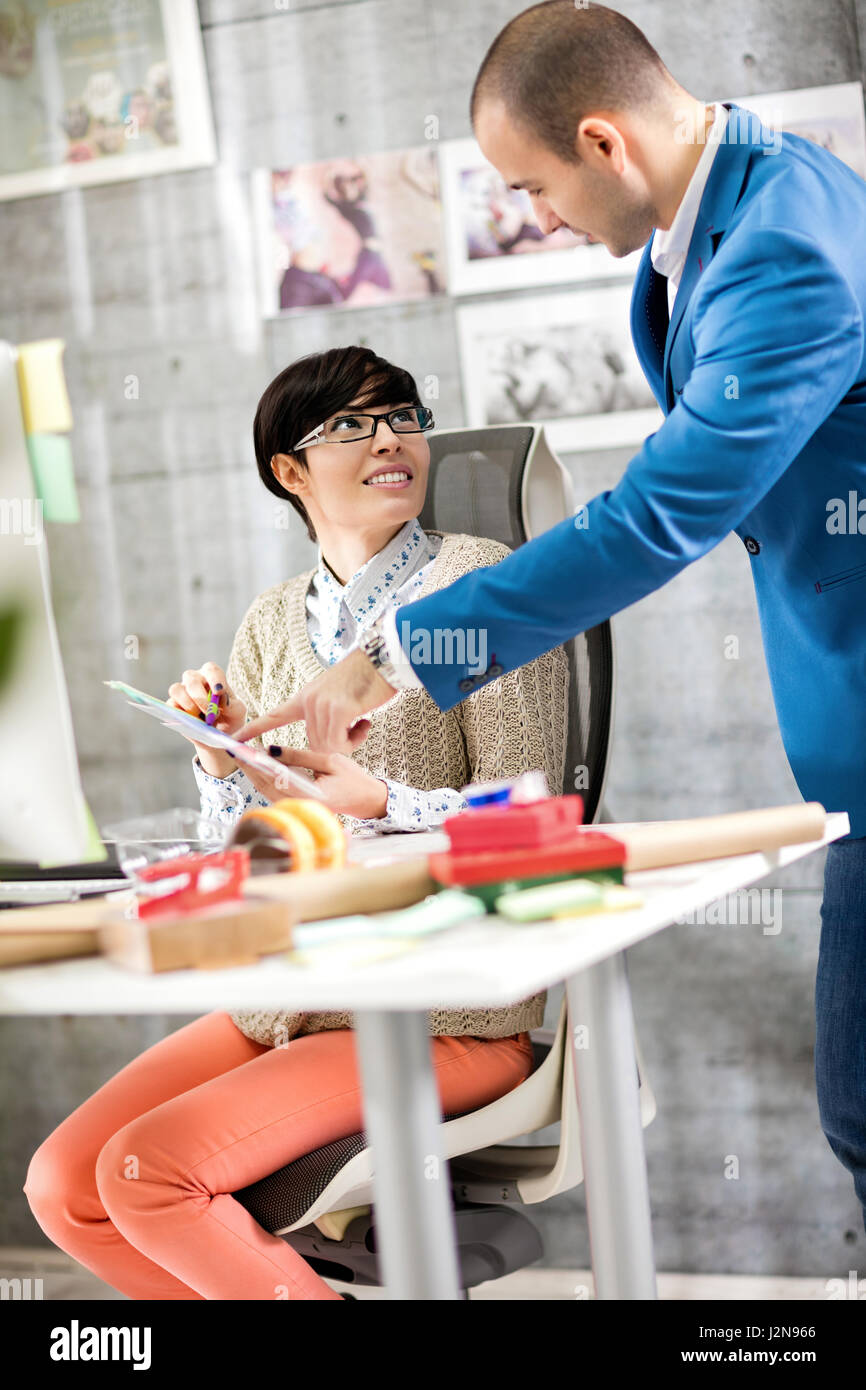 Young female designer in consultation with supervisor in design studio ...