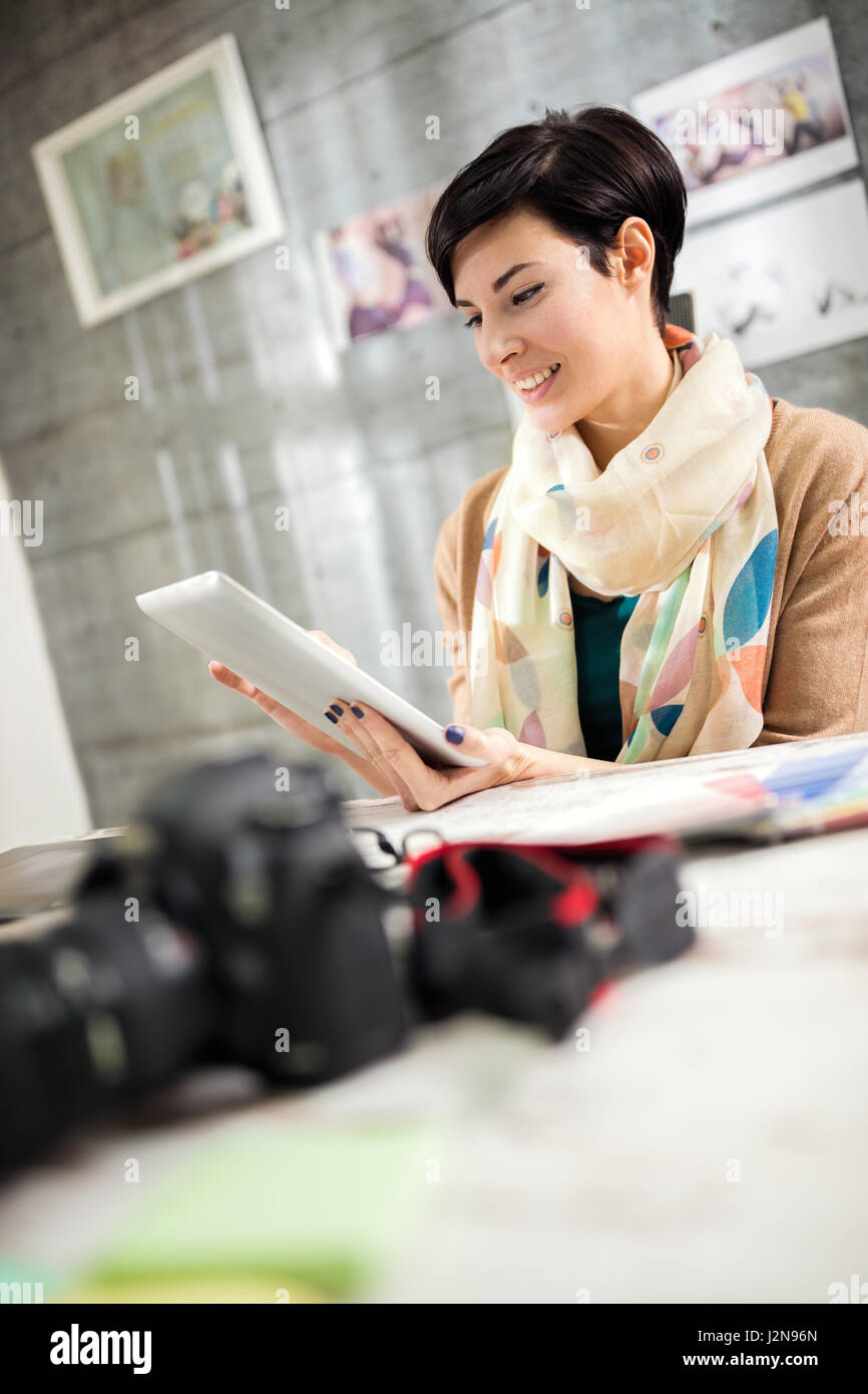 Designer corrects given photos in modern photo studio Stock Photo - Alamy