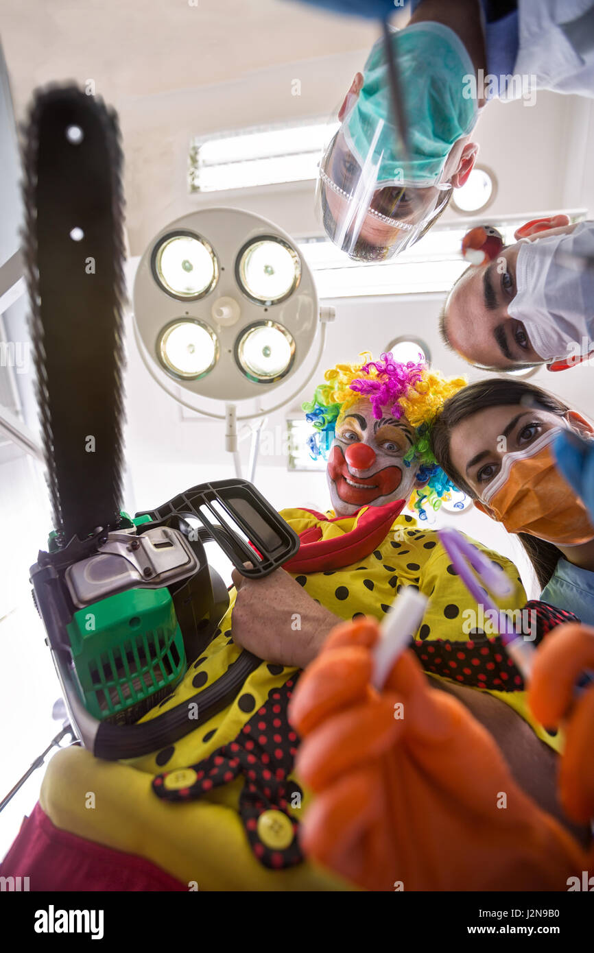 Nightmare delusion of dental operation with clown from horror holding ...