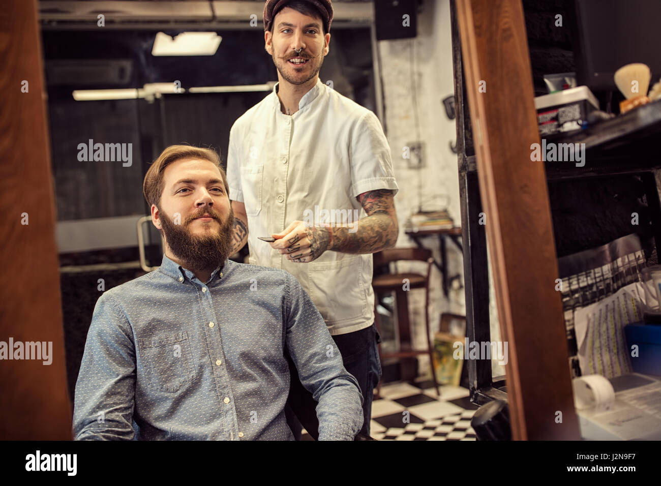 smiling male barber giving client haircut in shop Stock Photo - Alamy