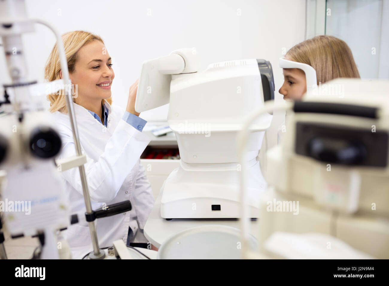 Pretty young doctor at clinic checking girls vision Stock Photo - Alamy