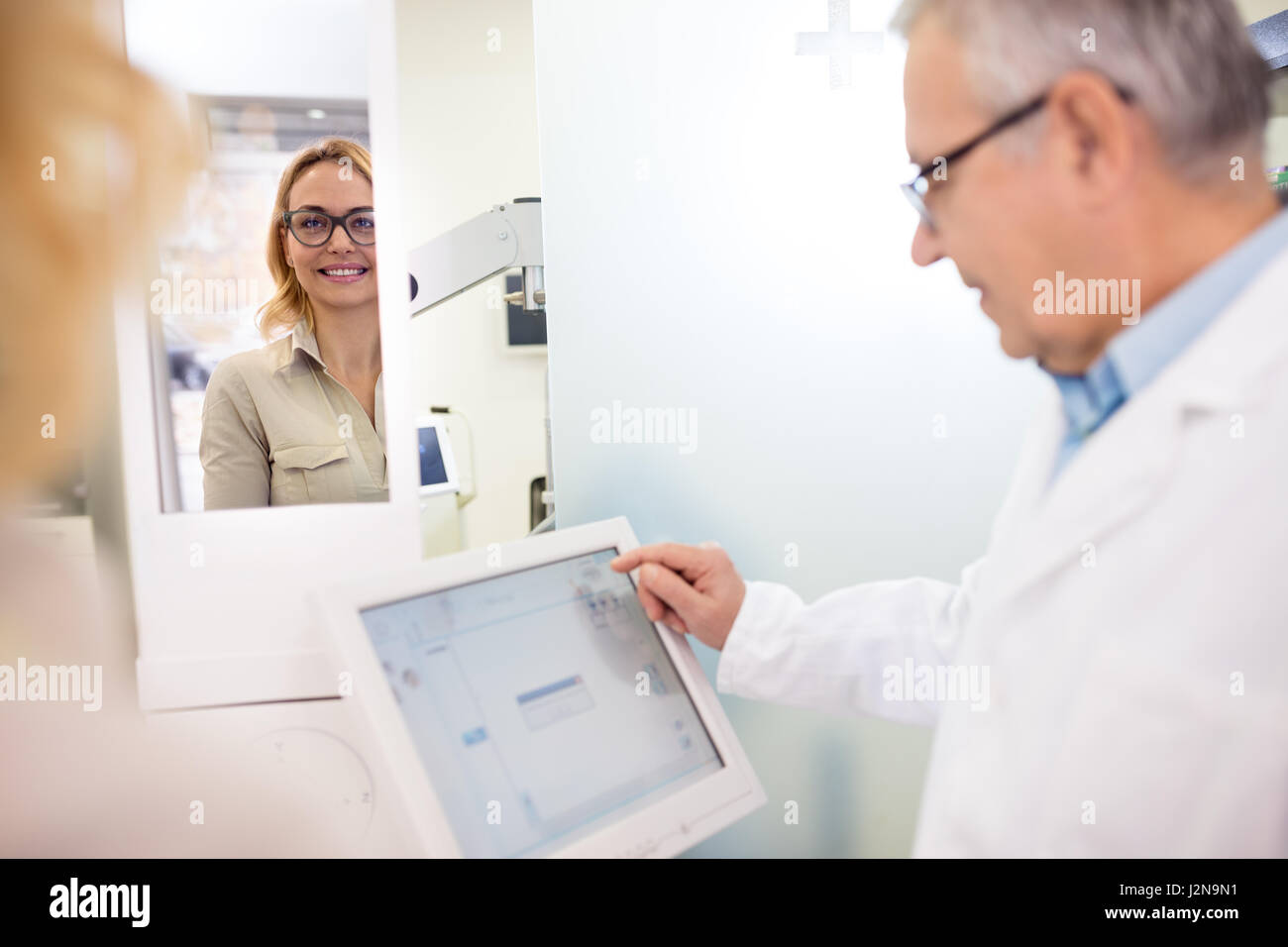 Blonde woman check her in mirror with new eyeglasses Stock Photo - Alamy