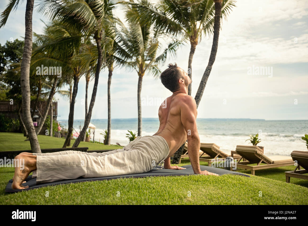 fit young man doing the cobra pose in nature near the ocean Stock Photo ...