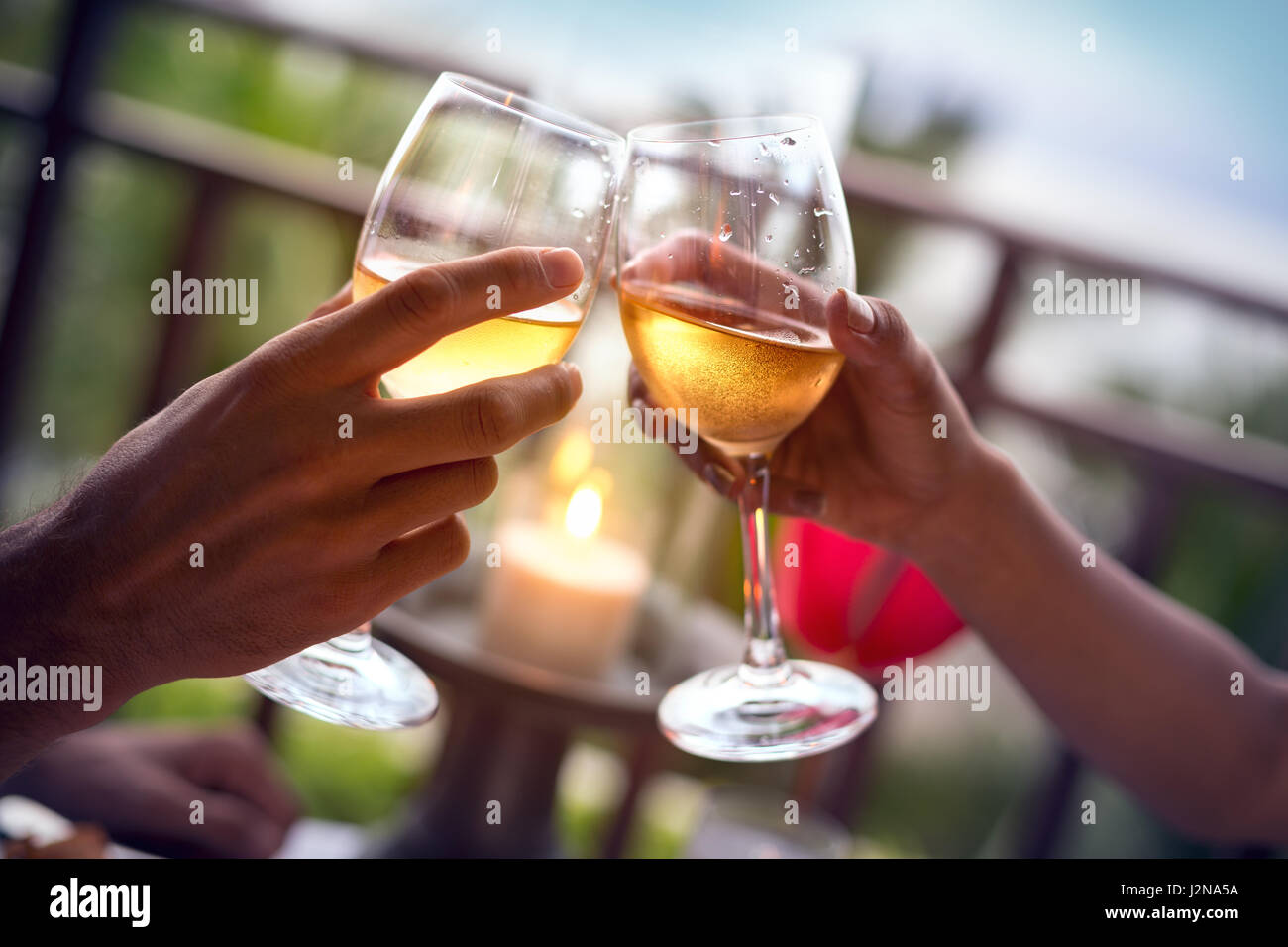 Couple cheering white wine glasses hi-res stock photography and images ...