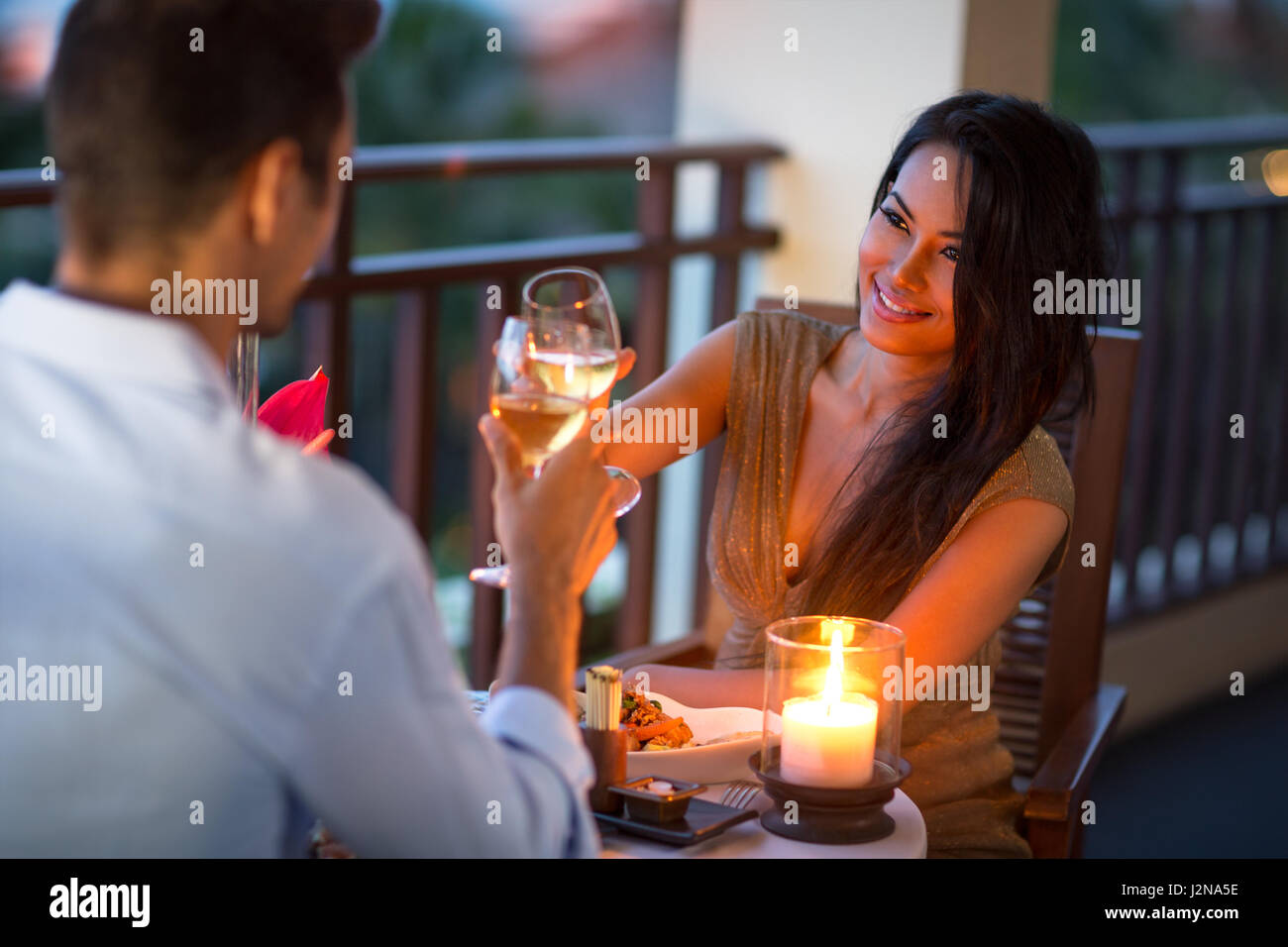 Couple having intimate dinner for two on the terrace of summer evening ...