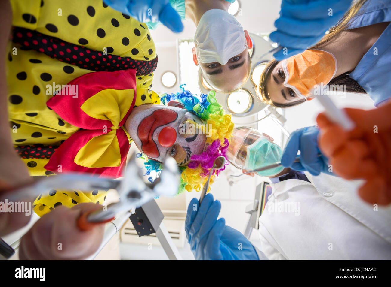 Bottom view of dental team working with funny clown Stock Photo - Alamy
