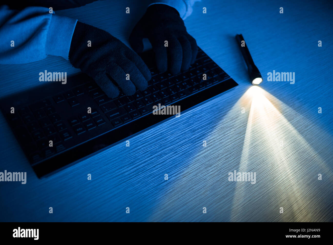 Hacker hand typing on keyboard with flashlight Stock Photo - Alamy