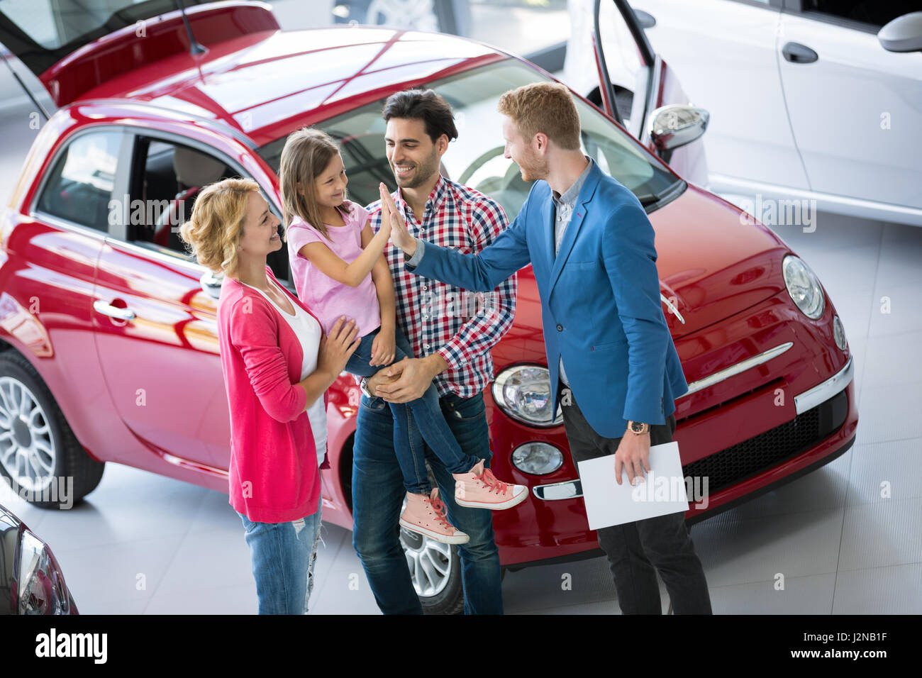 Cheerful family buy new car, salesman congratulated little girl Stock ...