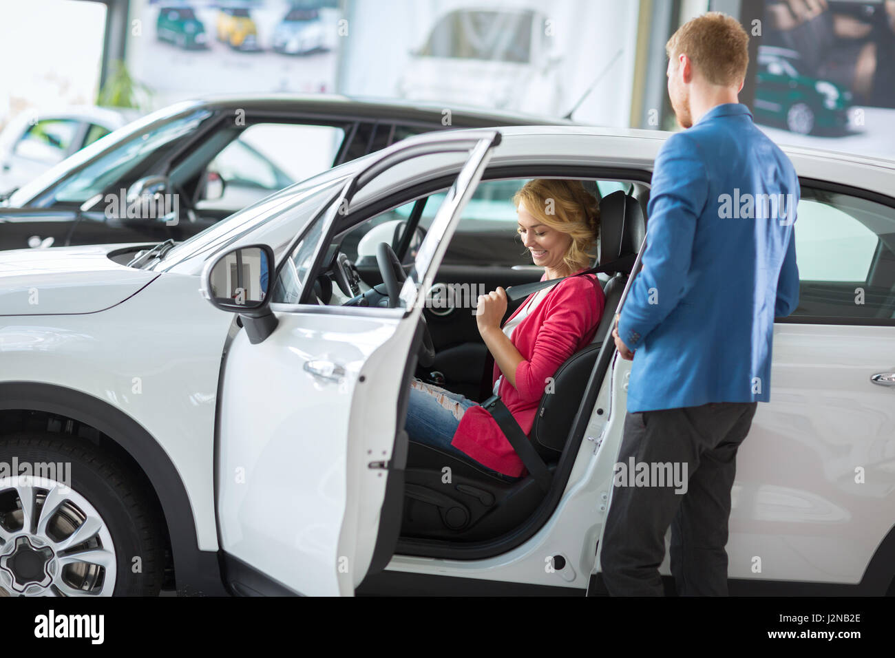 young woman test new model in the car dealership saloon Stock Photo - Alamy