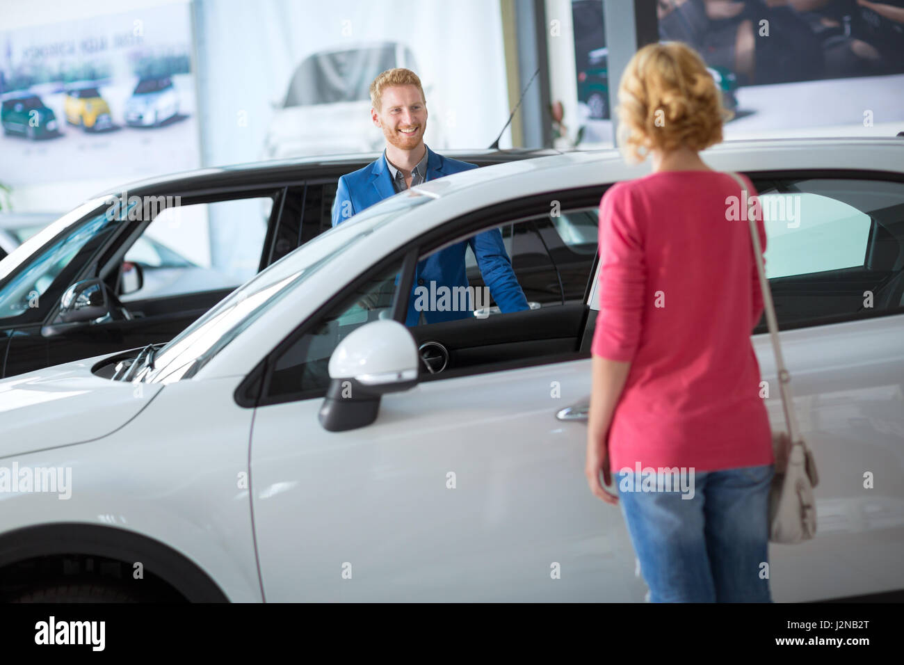 Dealer showing a new car model to the potential customer Stock Photo ...