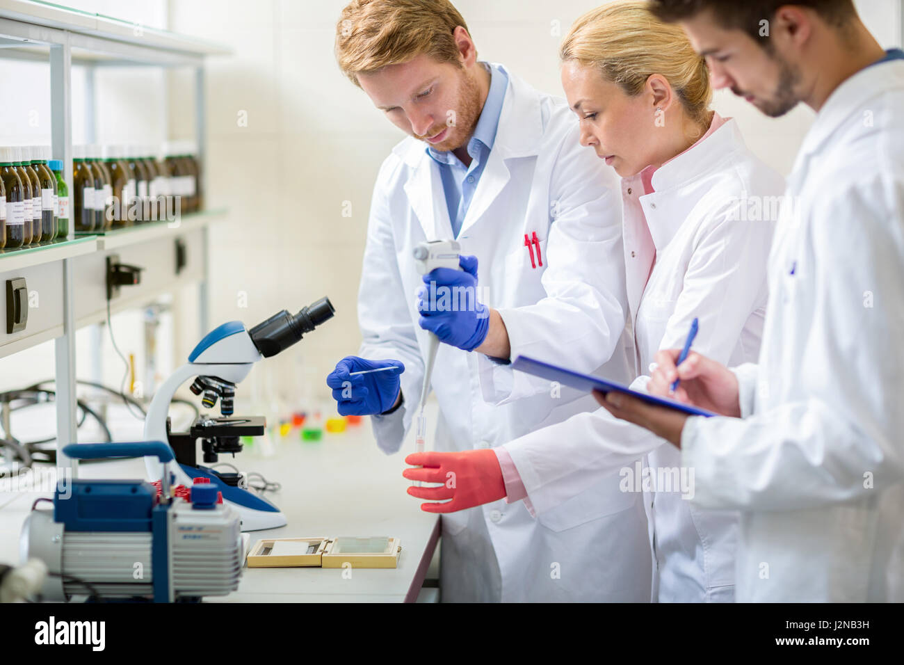 Young laboratory team worker works with microscope Stock Photo - Alamy