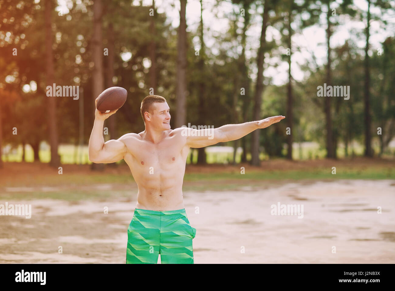 young and handsome male athlete posing for a photo holding ball Stock ...