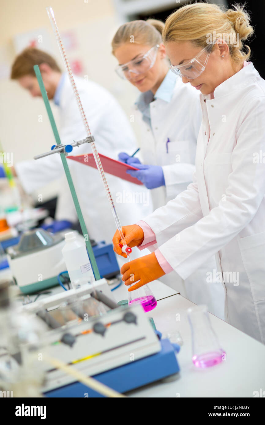 Young laboratory assistants measure test liquid in laboratory Stock ...