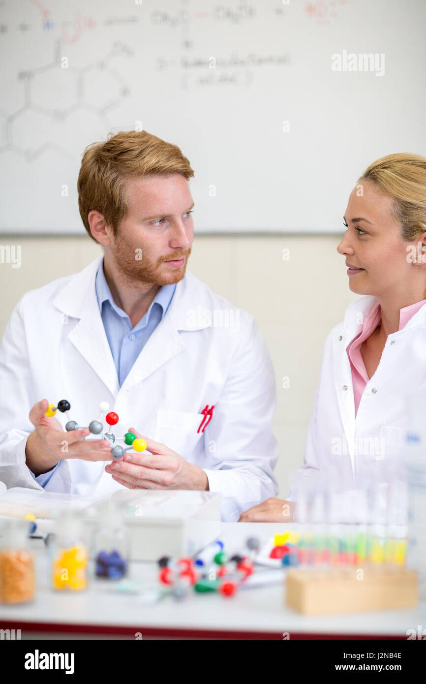 Chemical professor show molecular model to young female assistant Stock ...