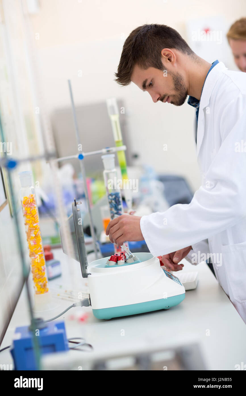 Male chemical technician put test tube in shaker in laboratory Stock ...