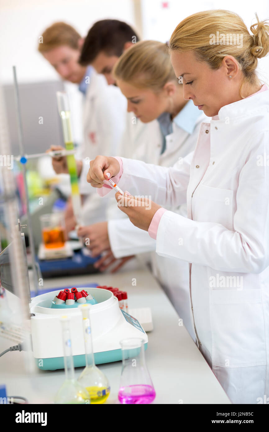 Laboratory female worker checking test tube in lab Stock Photo - Alamy