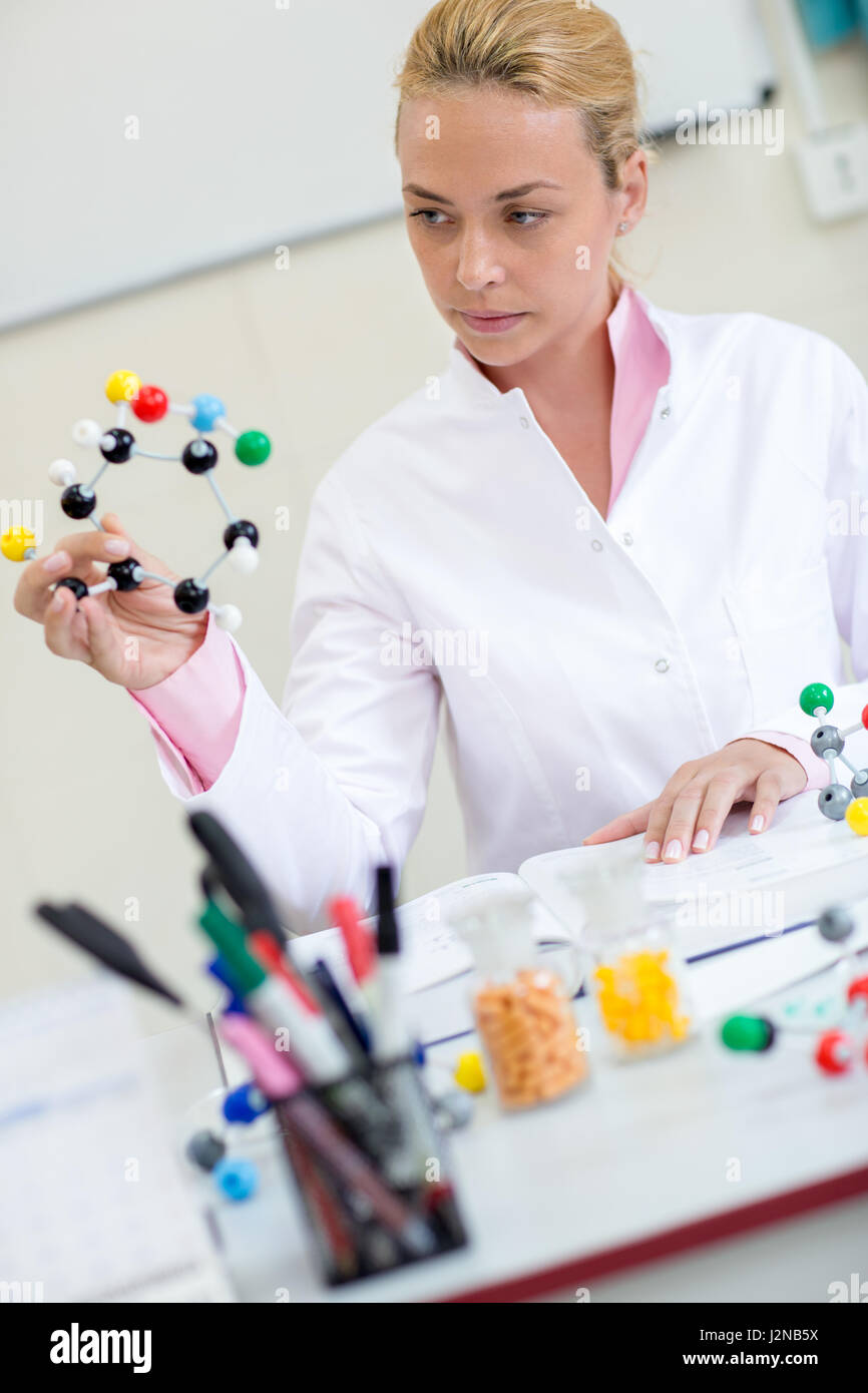 Young female chemistry teacher observing molecular structure in ...