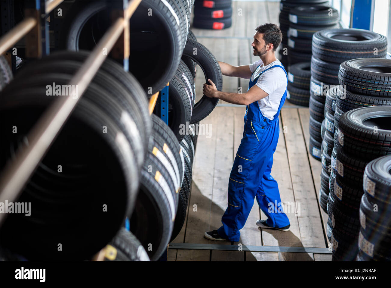 Auto mechanic choose tire for car at a tire store Stock Photo - Alamy
