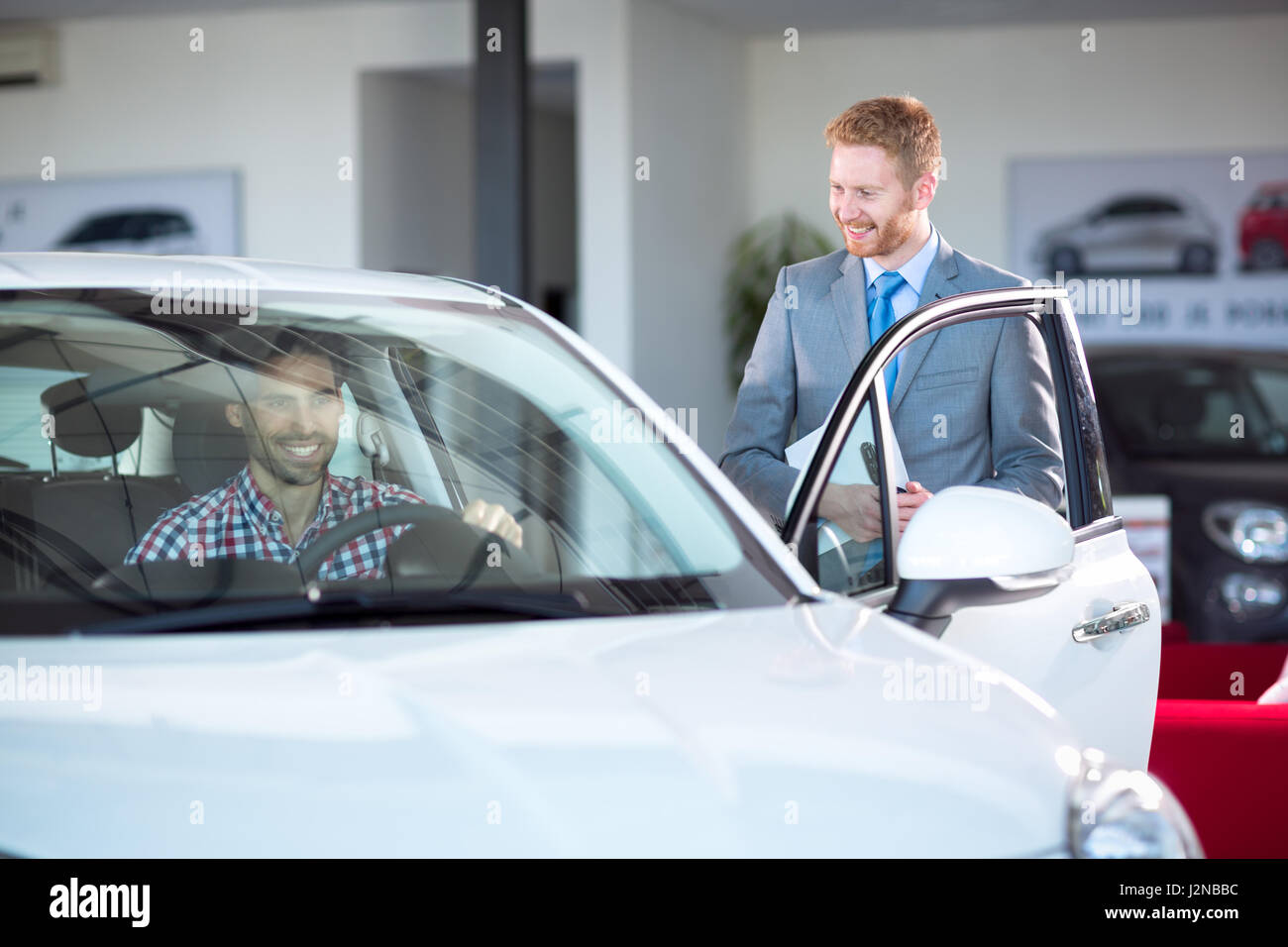 car dealer showing new car to customer Stock Photo - Alamy