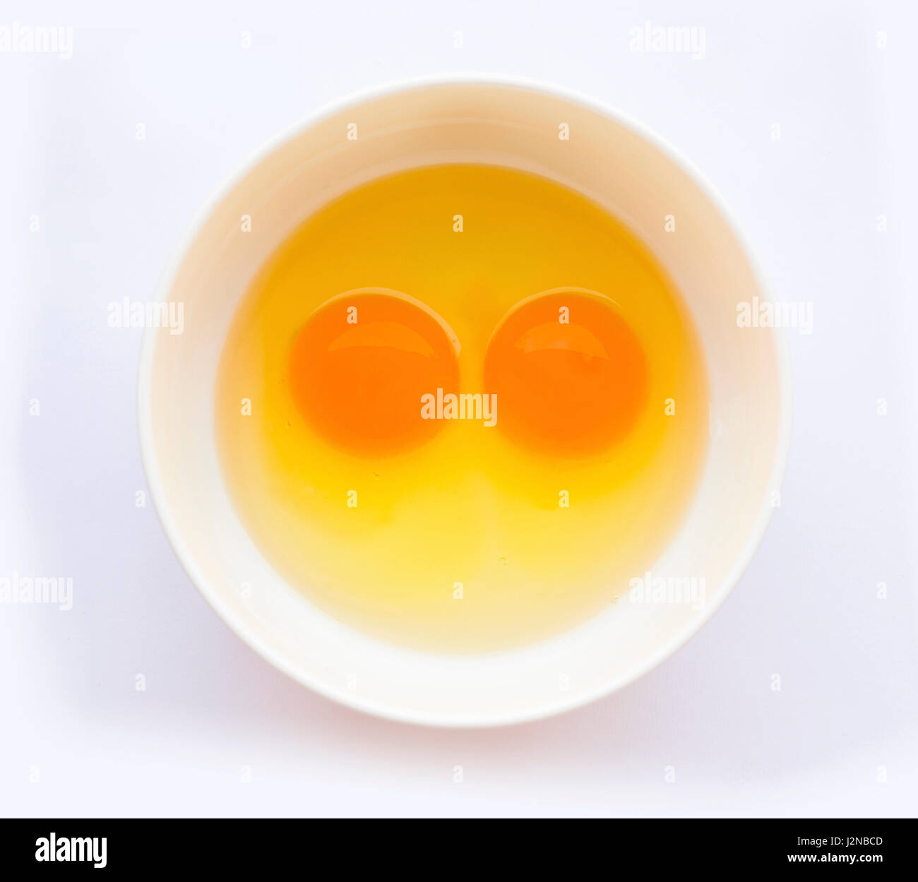 Two uncooked eggs in white bowl isolated on white background Stock ...