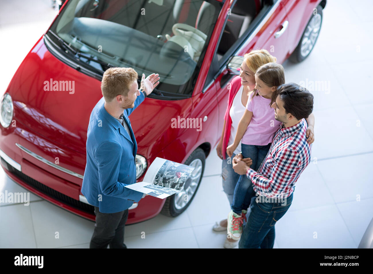 Young family with car agent in the car dealership saloon Stock Photo ...