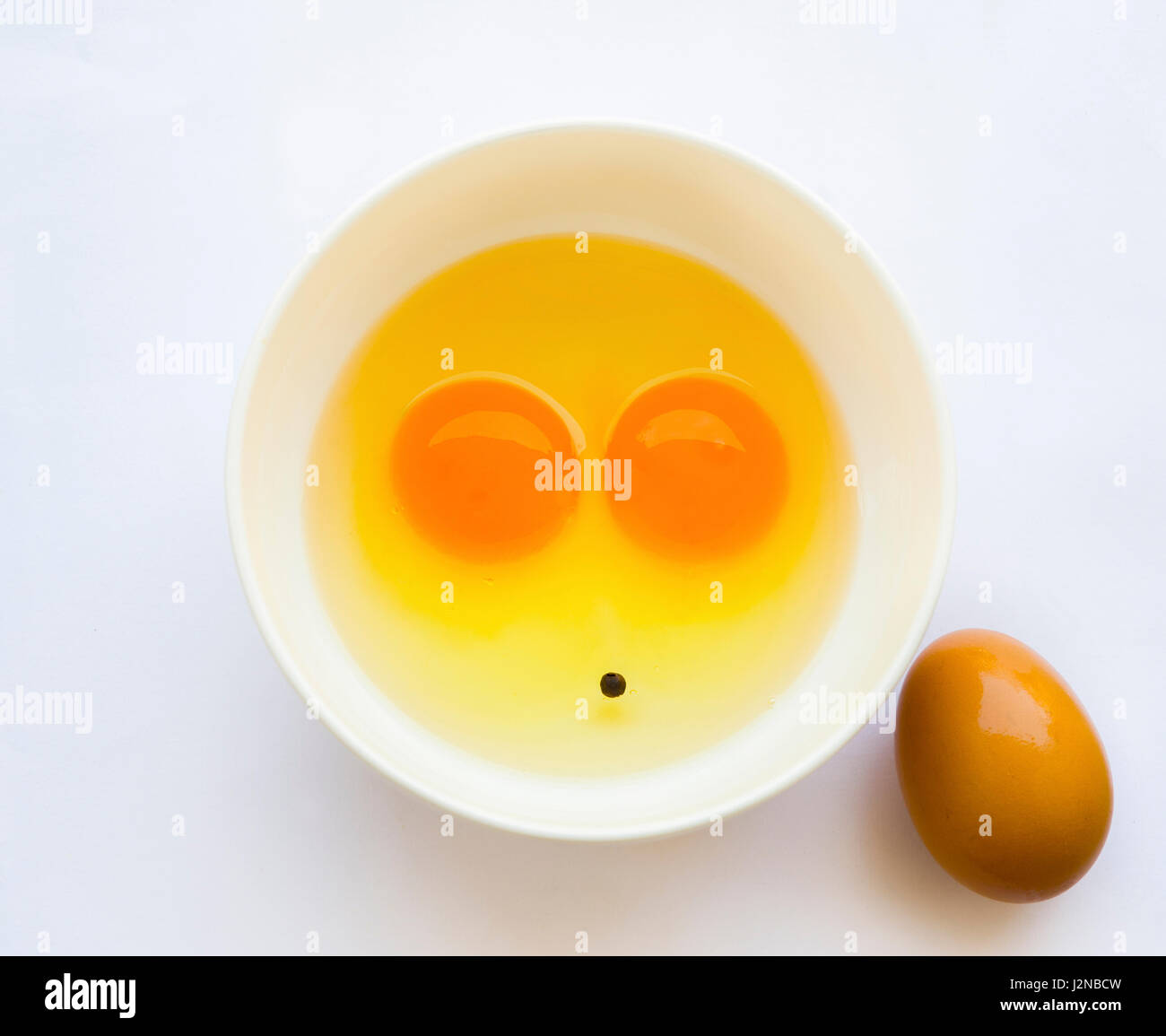Two uncooked eggs in white bowl isolated on white background Stock ...