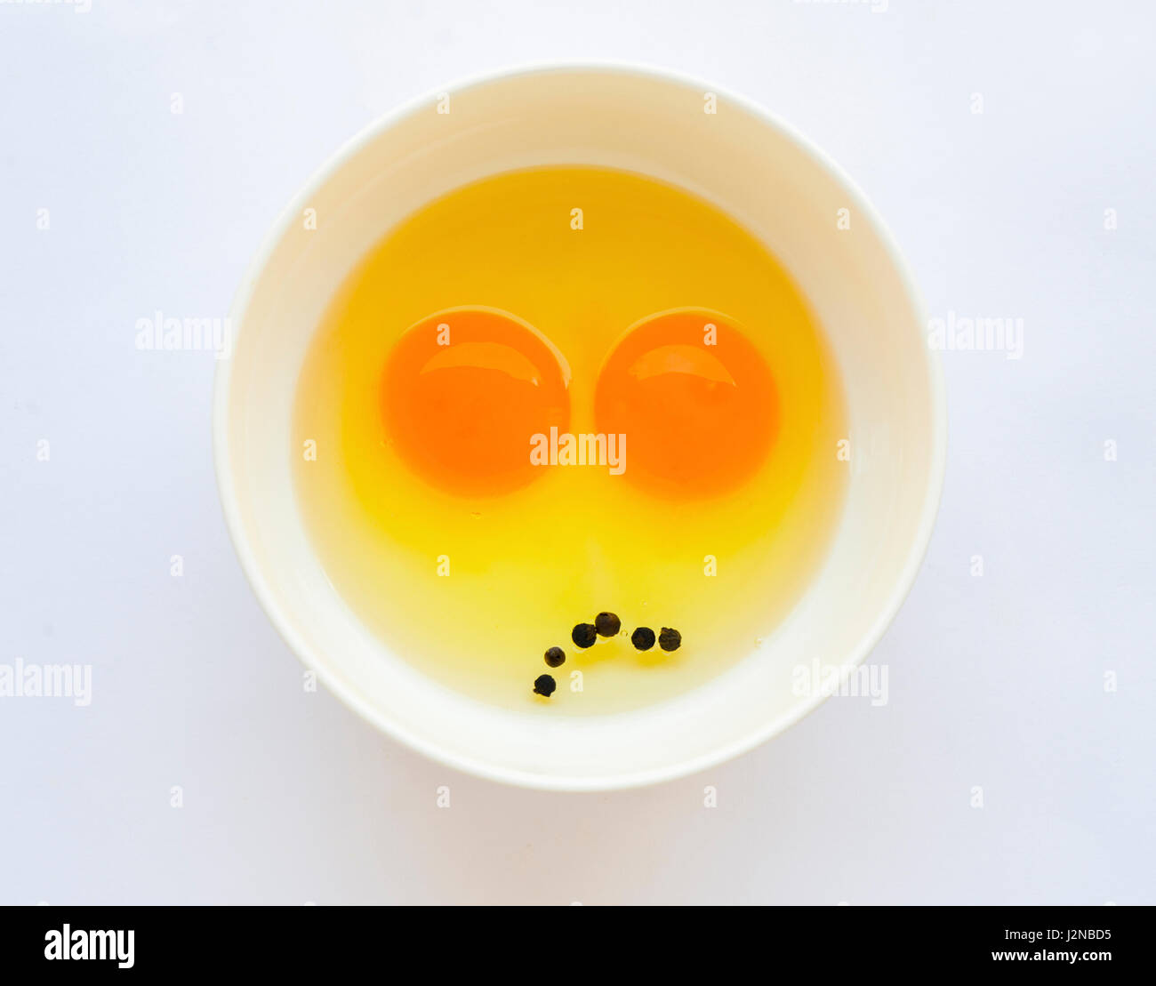 Two uncooked eggs in white bowl isolated on white background Stock ...