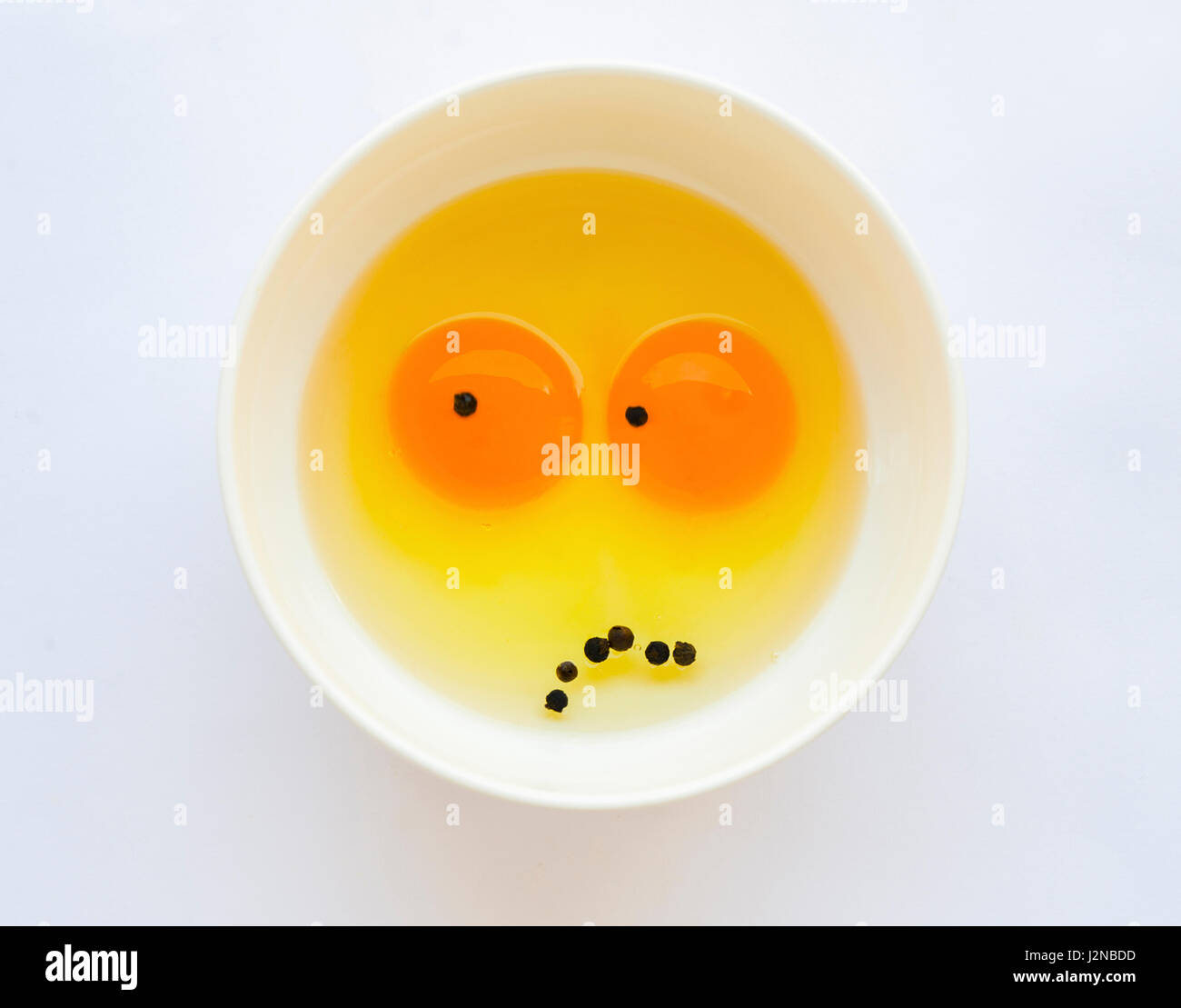 Two uncooked eggs in white bowl isolated on white background Stock ...