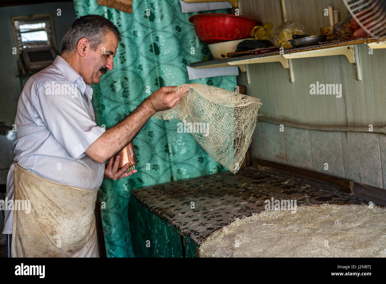 Rustam Hasanov, a baklava master, prepares the pastry at his kitchen ...