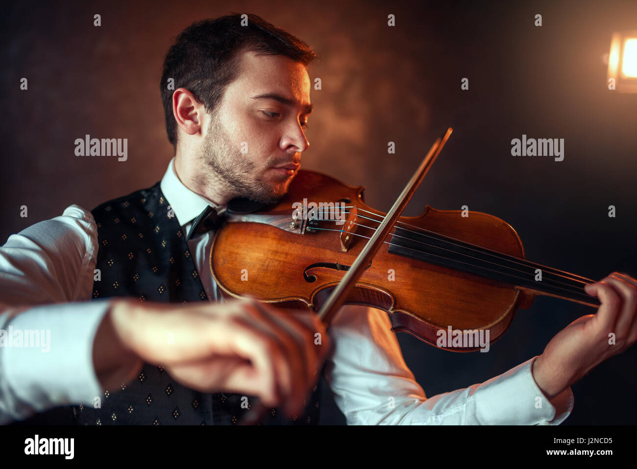 Portrait of male fiddler playing classical music on violin. Violinist ...