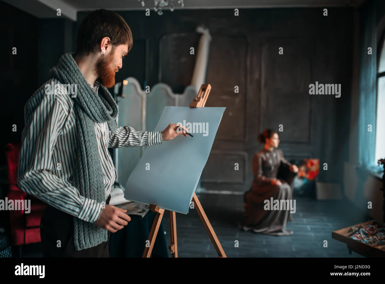 Painter drawing female portrait against easel in art studio. Oil paint ...
