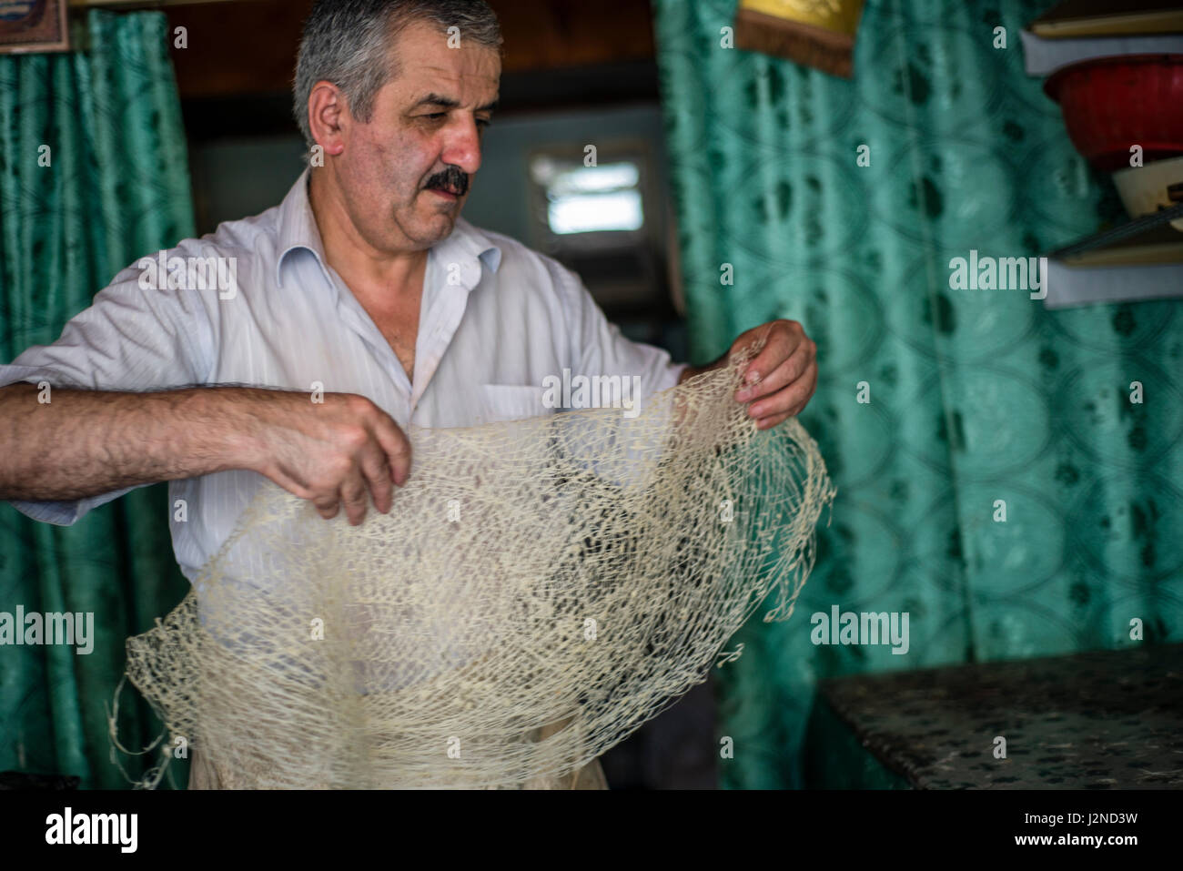 Rustam Hasanov, a baklava master, prepares the pastry at his kitchen ...