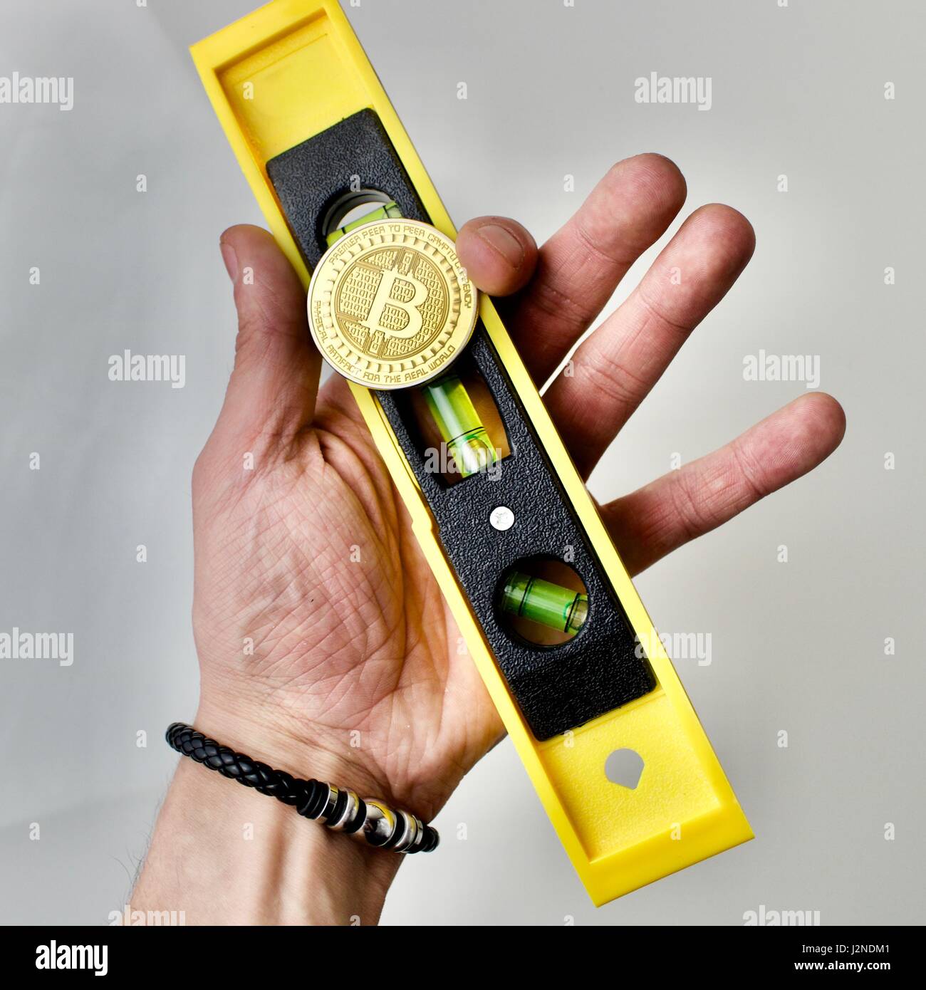 Level scale with bitcoin coin in hand Stock Photo - Alamy