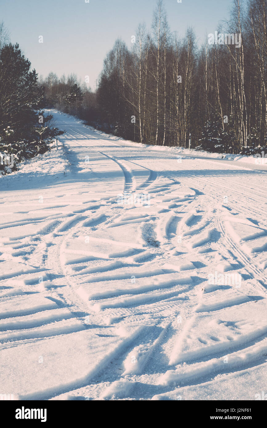 snowy winter road with tire markings and blue sky - retro vintage ...