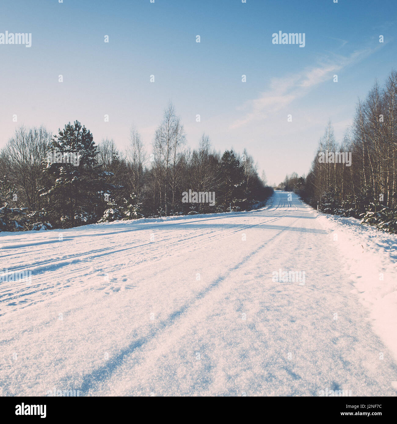 snowy winter road with tire markings and blue sky - retro vintage ...