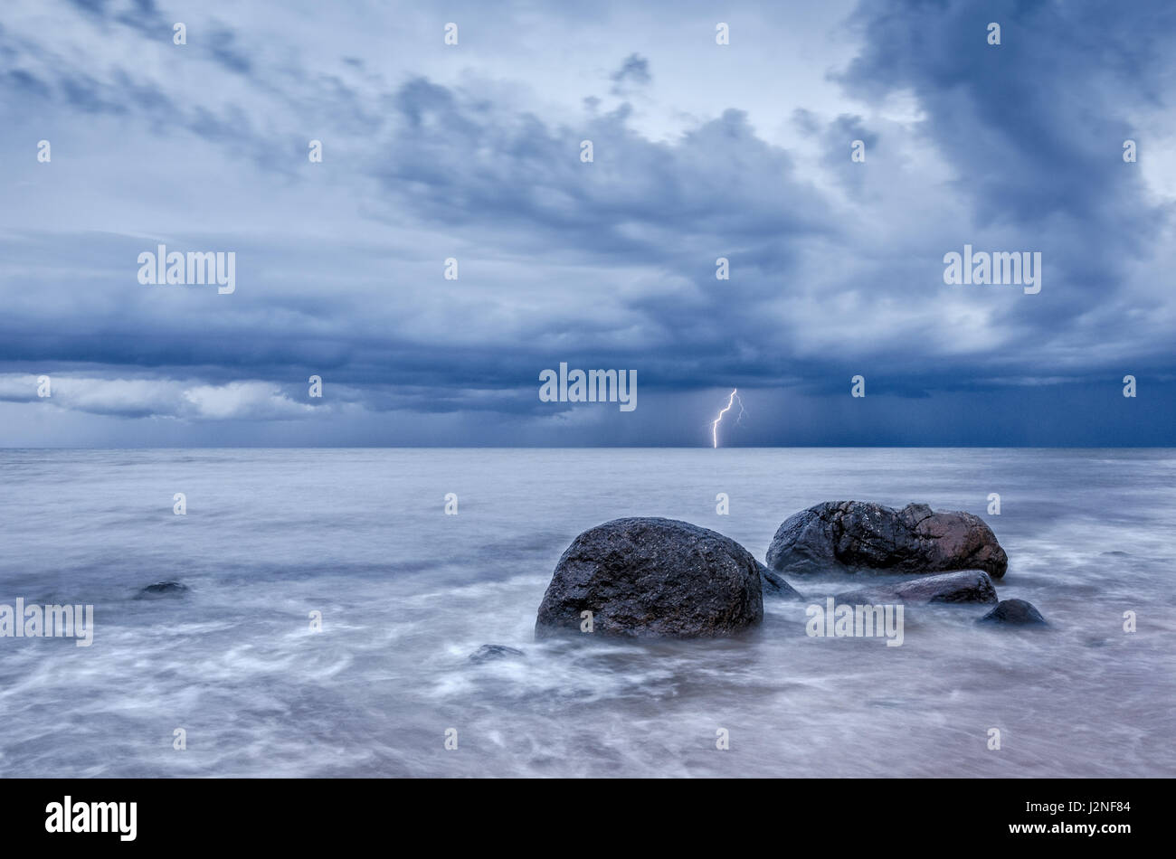 Seascape. Storm clouds gathering over the rocky beach Stock Photo - Alamy