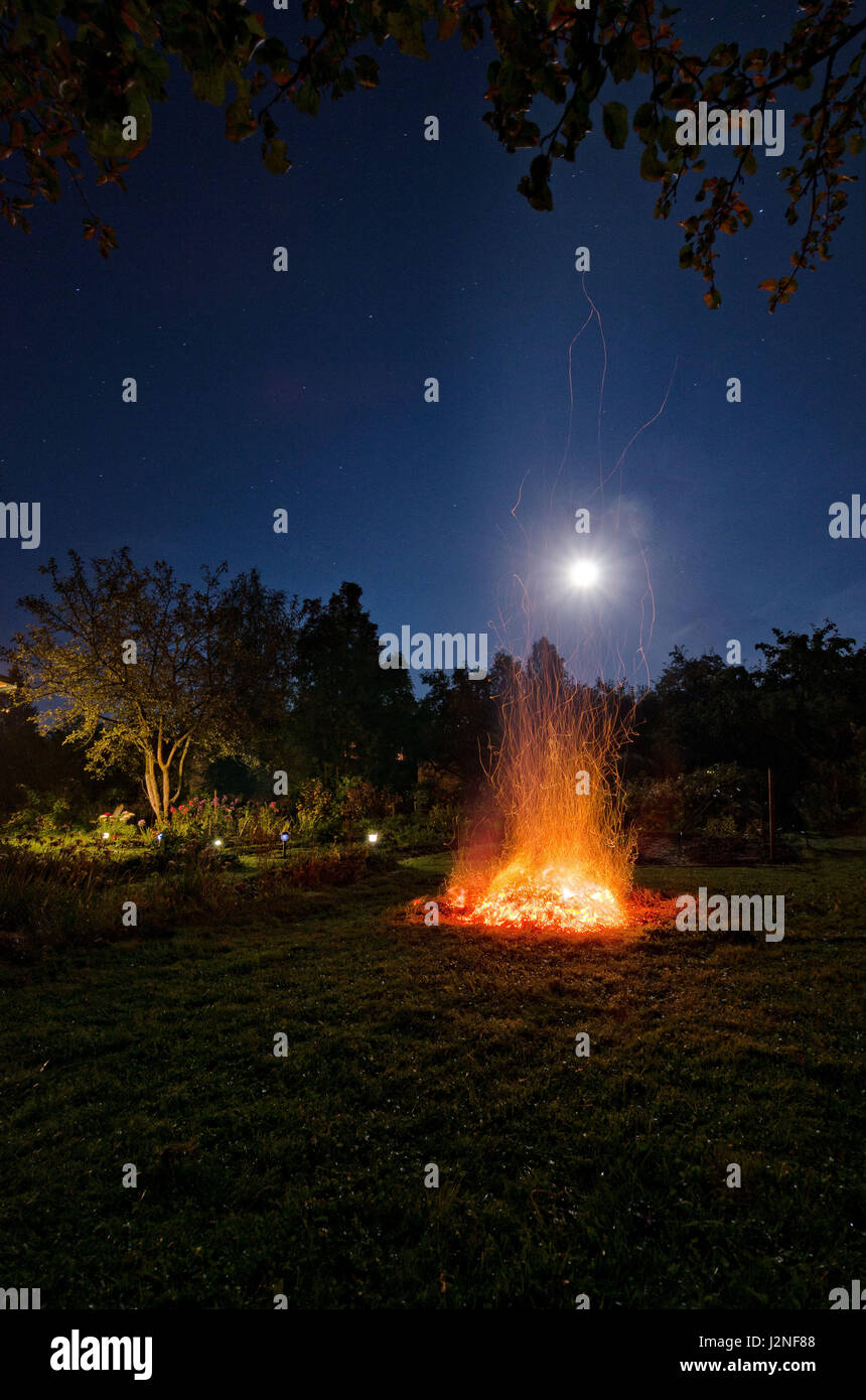 Garden night landscape with moon and bonfire Stock Photo - Alamy