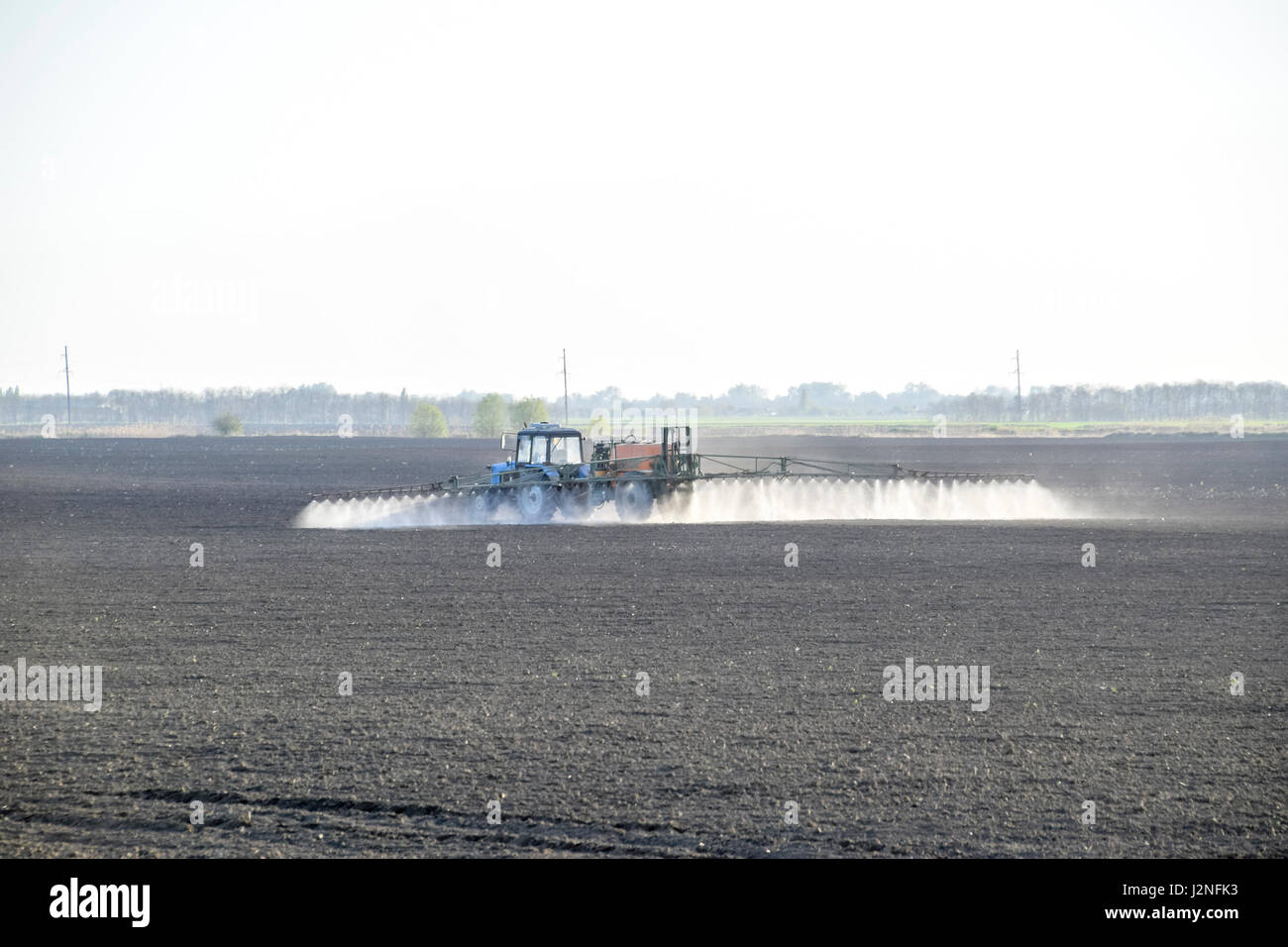 The tractor sprayed herbicides on the field. Chemistry in agriculture ...