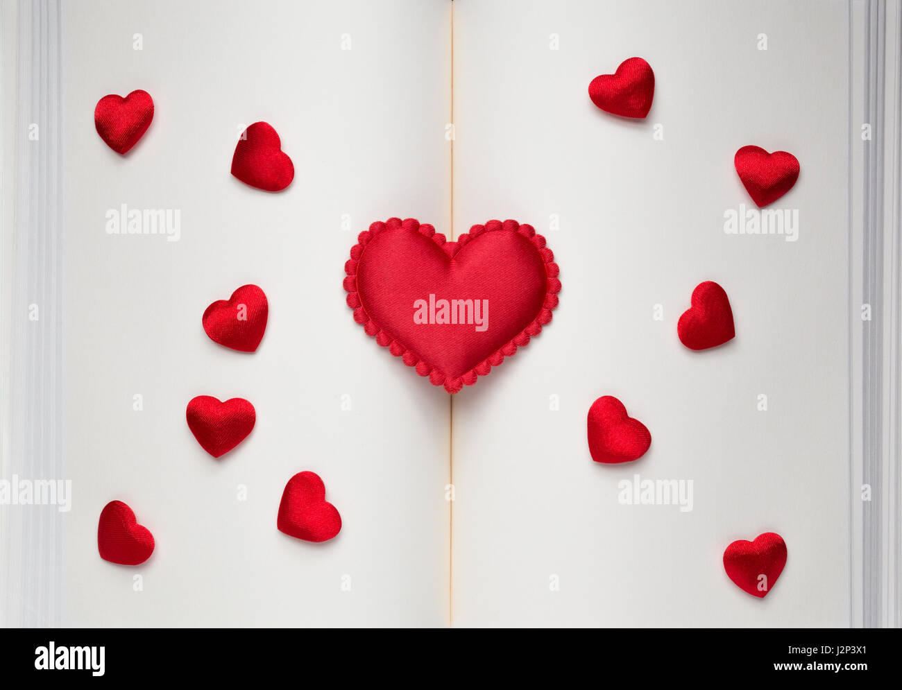 Big red heart and small red hearts on open book with empty pages, space ...