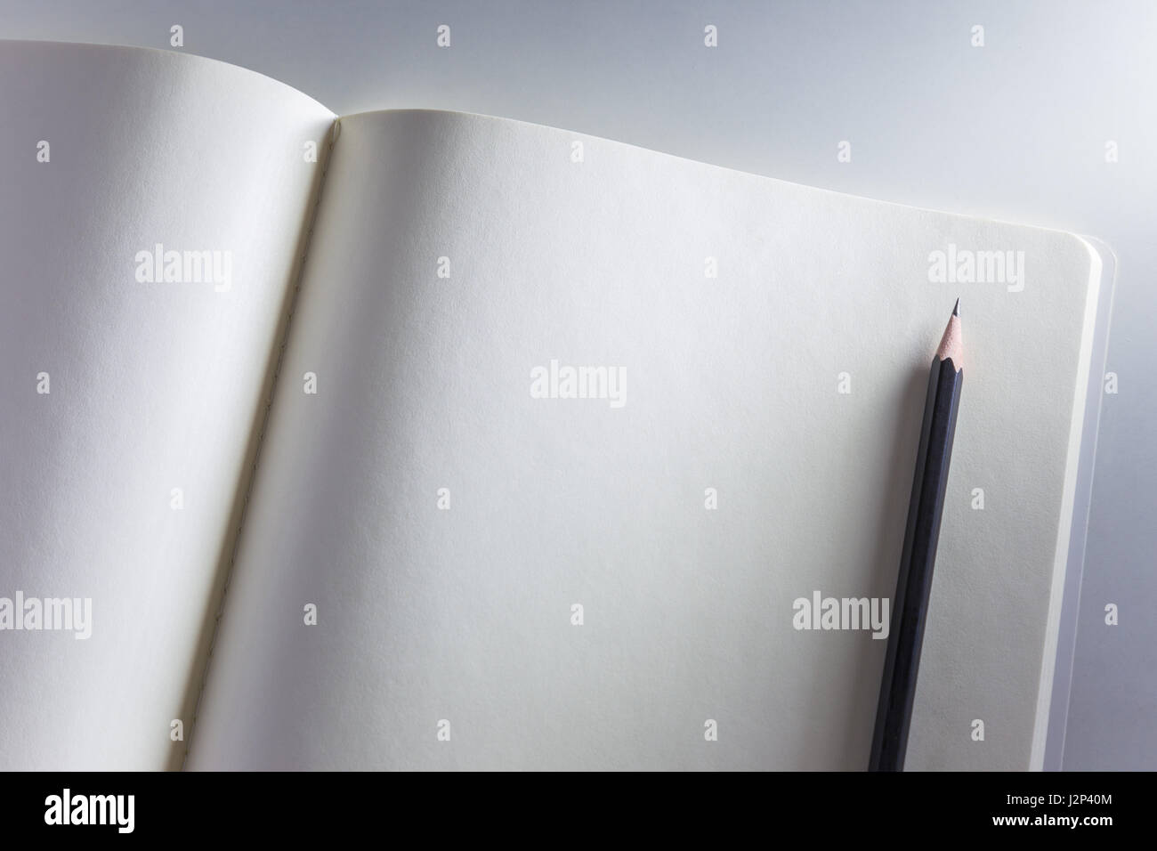Opened blank white notebook and pencil on white background with side ...