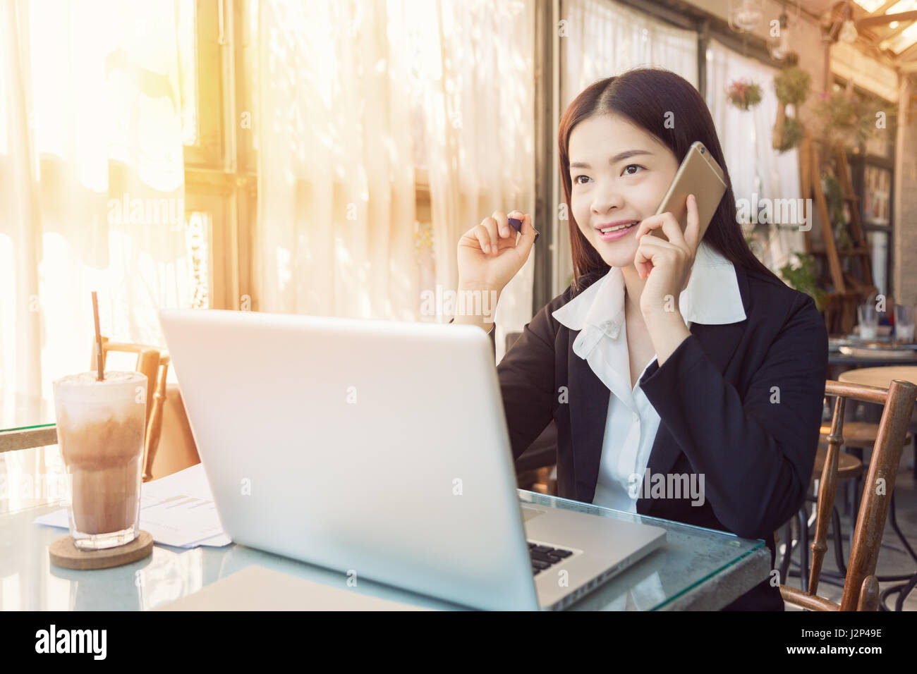 Smiling young asian executive business woman working on her computer ... Smiling young asian executive business woman working on her computer ...