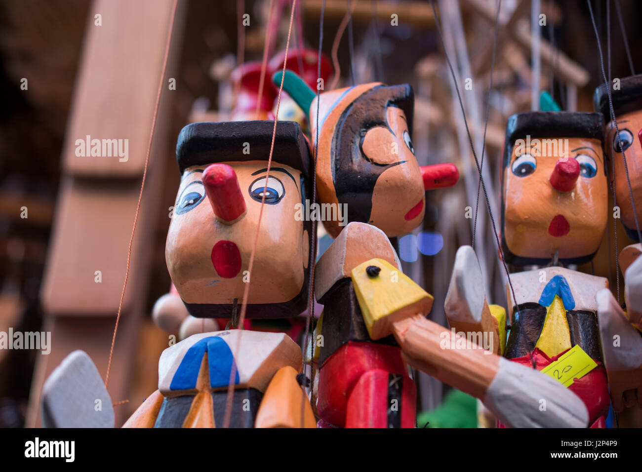 Set of wooden pinocchio dolls with his long nose on a white background ...