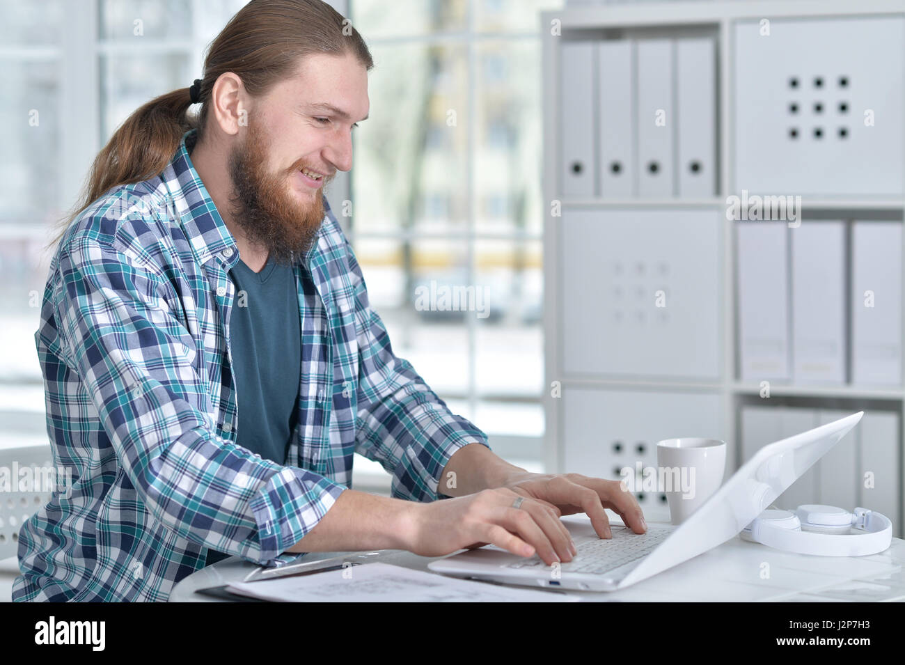 Young business man with laptop working Stock Photo - Alamy