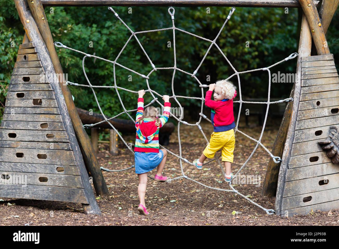 Active children playing on climbing net at school yard playground. Kids ...