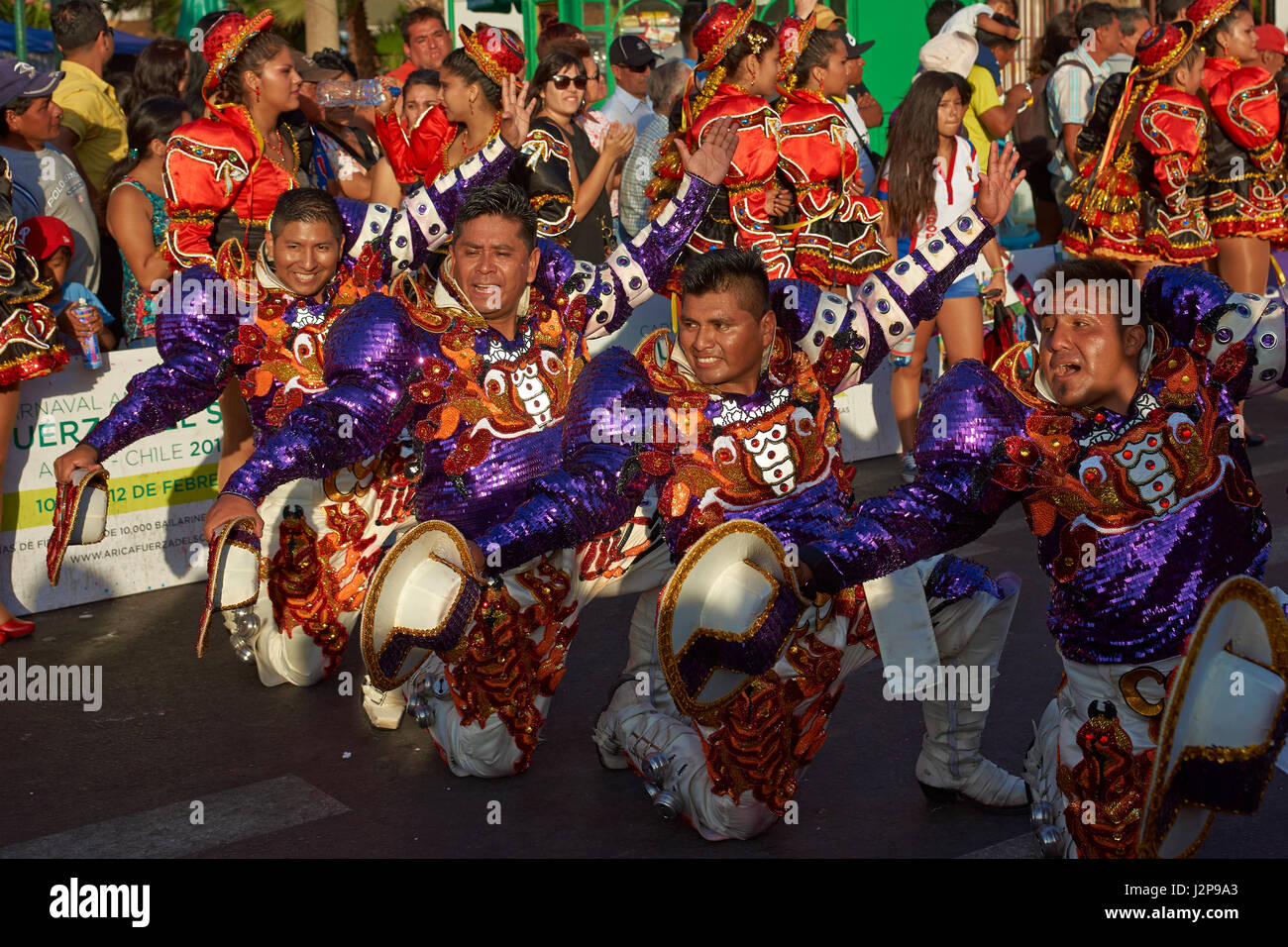 Male members of a Caporales dance group in ornate costumes performing ...