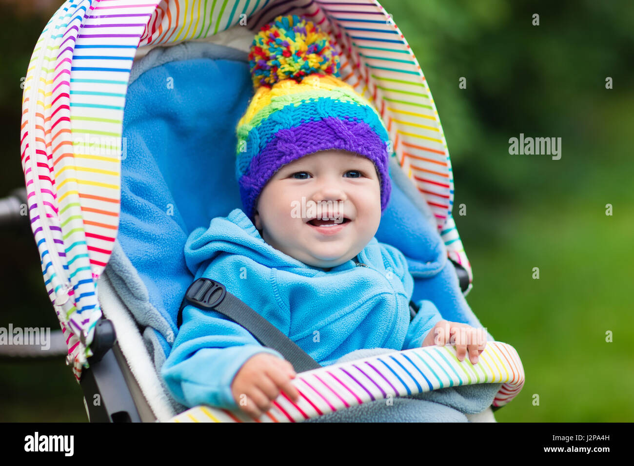 Baby in stroller on a walk in autumn park. Adorable little boy with ...
