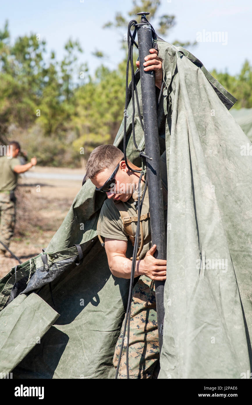 A U.S. Marine from MWSS-274 lifts a support beam during Base-Ex tent ...